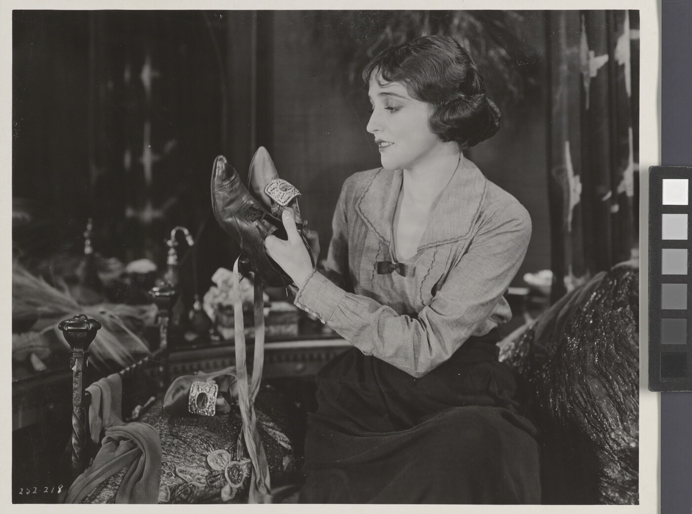 [Agnes Ayres sitting on bed, comparing work and dress shoes, "Forbidden ...