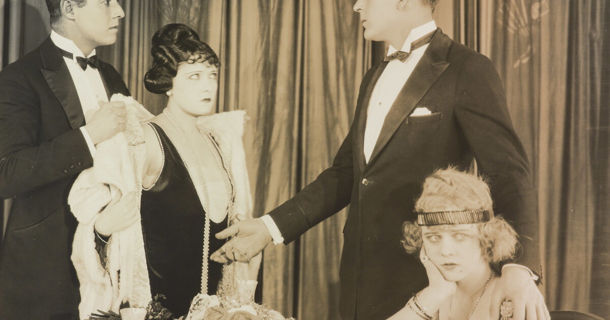 [Elliot Dexter helping Gloria Swanson with coat, Wallace Reid with hand ...