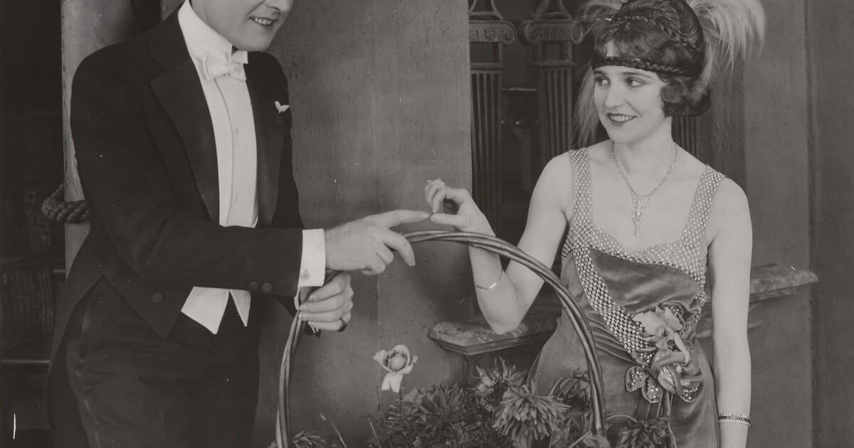 [Forrest Stanley and Agnes Ayres standing by large basket, both in ...