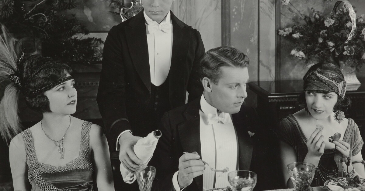 [Forrest Stanley talking to woman, Theodore Kosloff pouring wine for ...